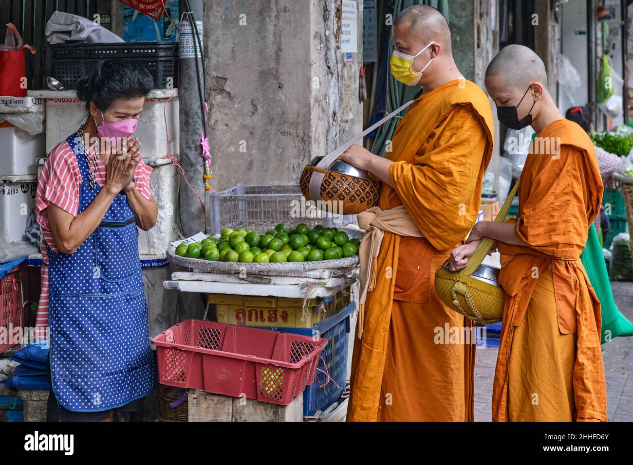 During their morning alms round, a Thai Buddhist monk and a novice are ...