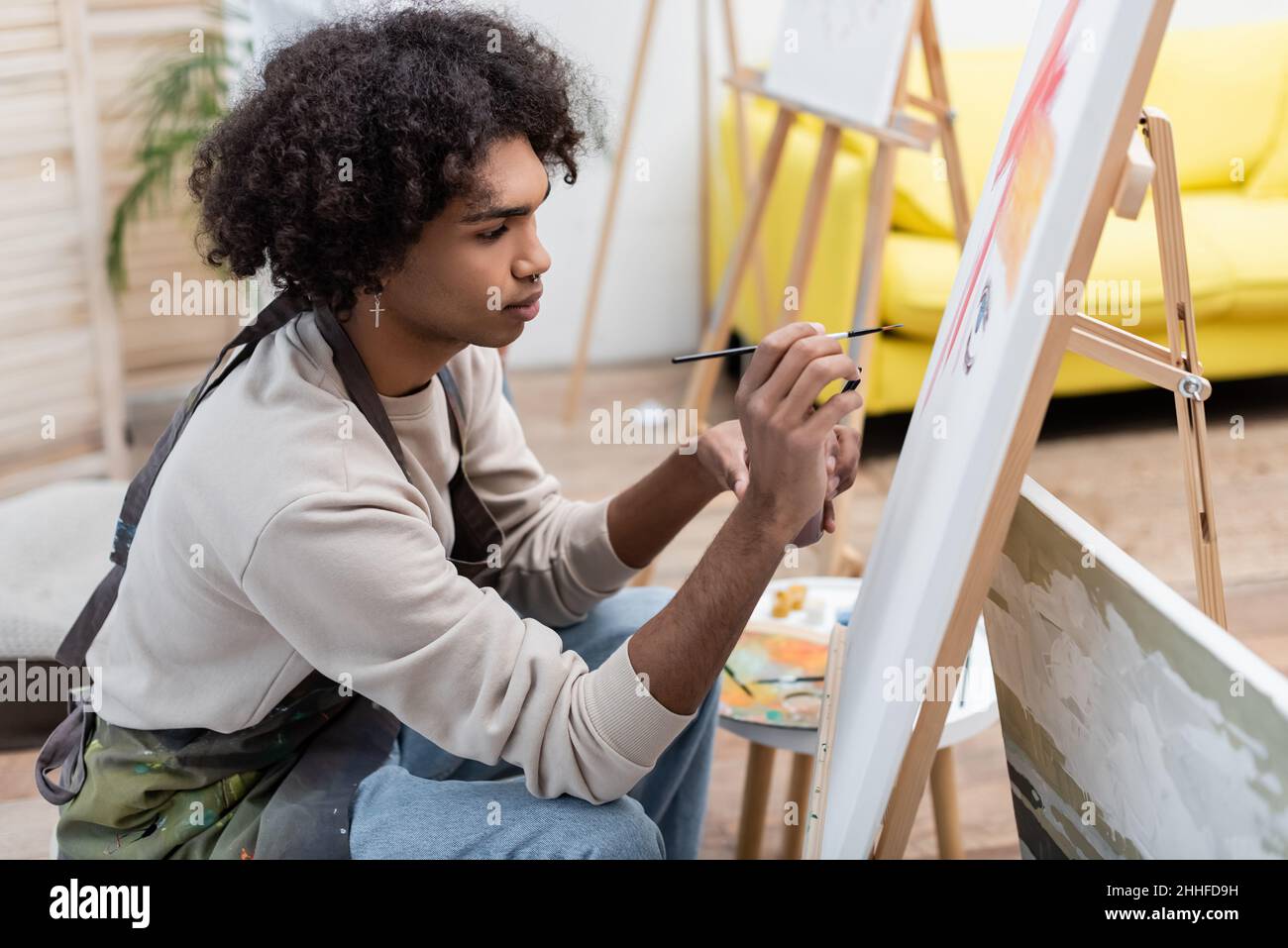 Young african american man painting on canvas at home Stock Photo - Alamy