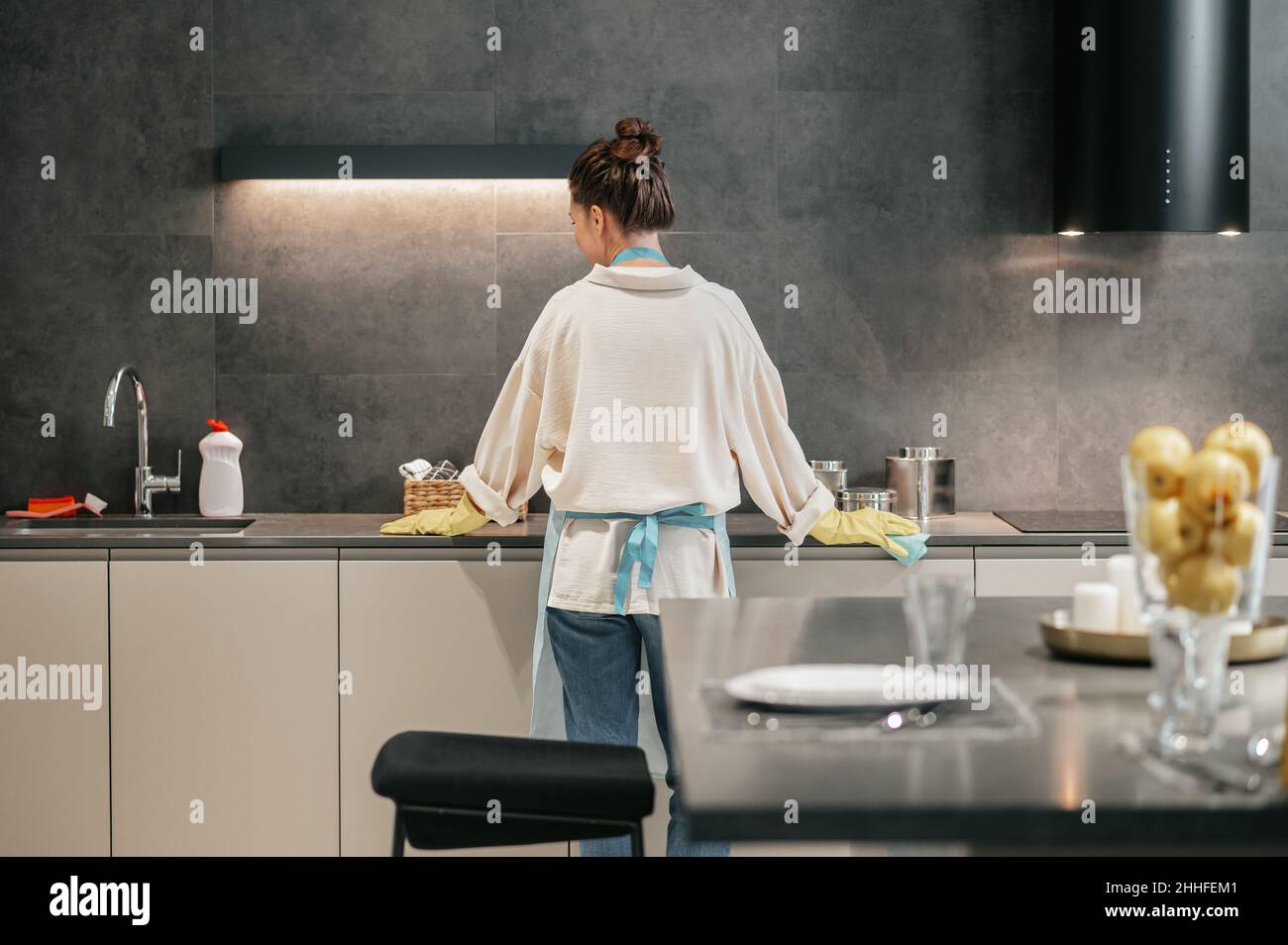 A woman looking busy while cleaning the kitchen Stock Photo - Alamy