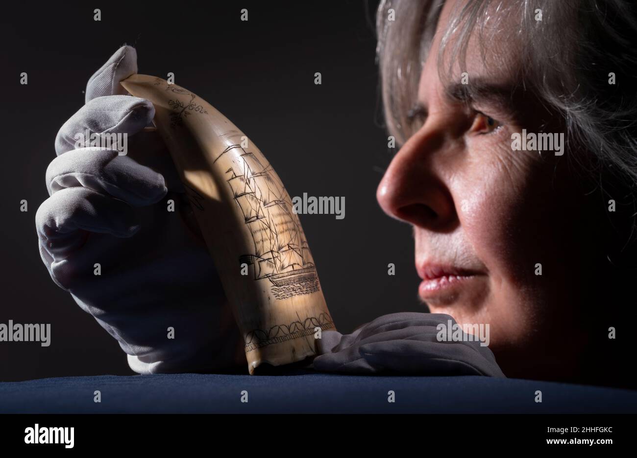 Curator Kitty Ross Abbey with a whale tooth with a scrimshaw carving ...