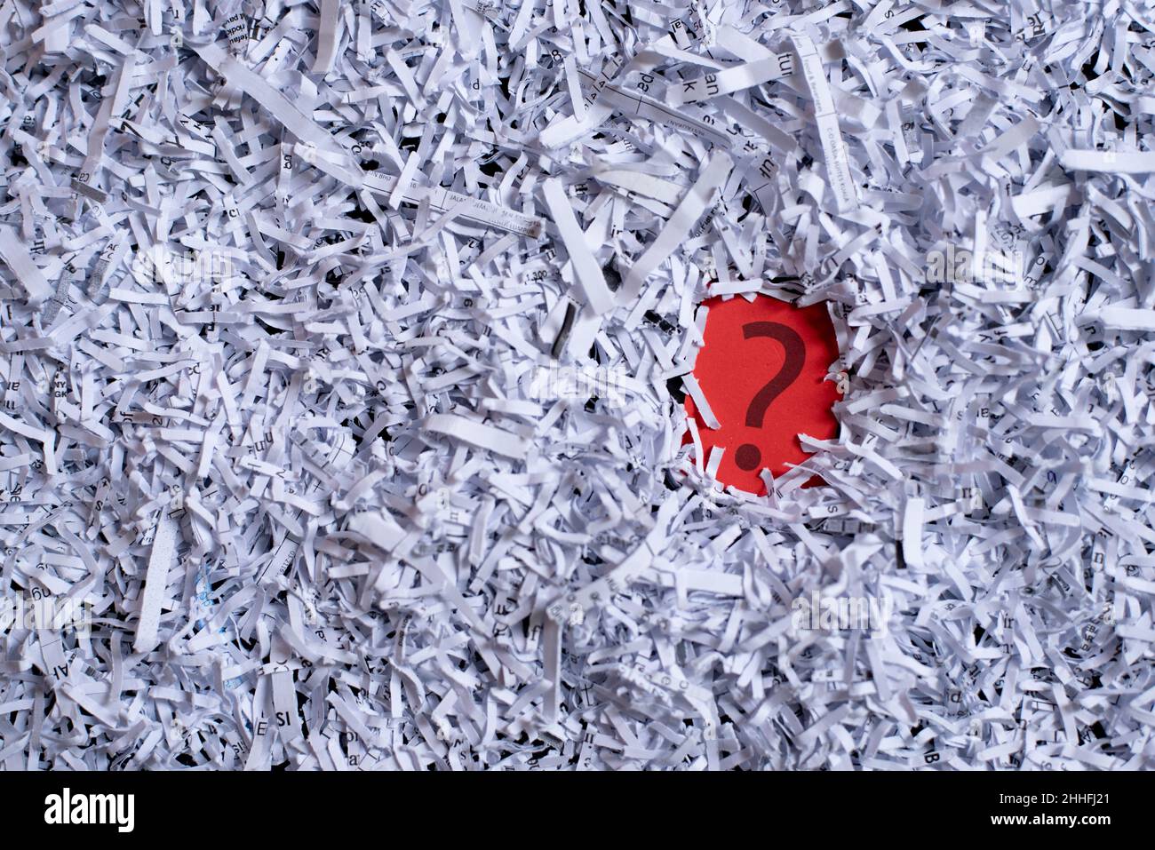 white shredded paper revealing a question mark. Concept of questions ...