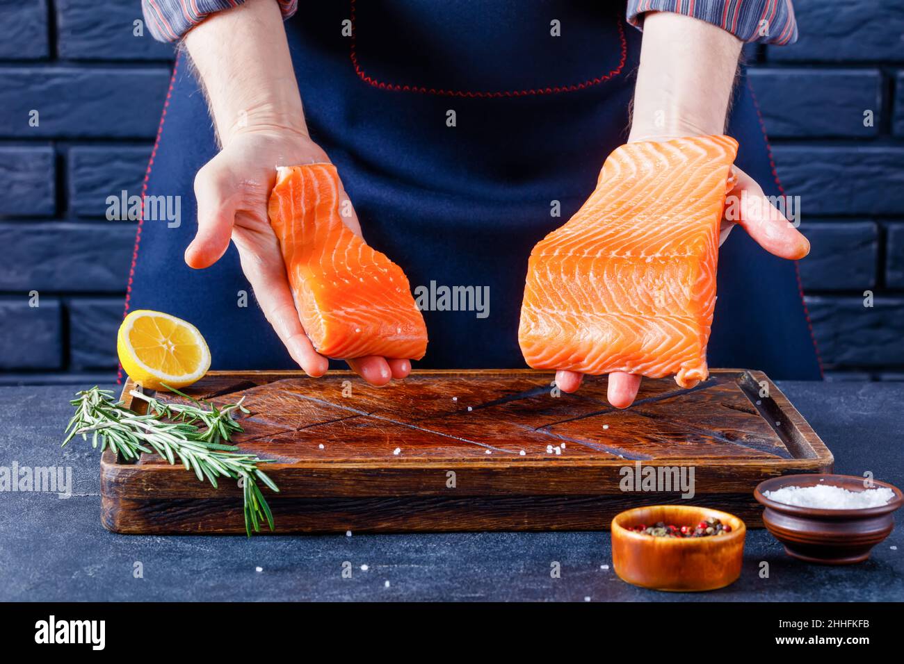 Man is showing pieces of salmon fillet. Chef demonstrating a fish ...