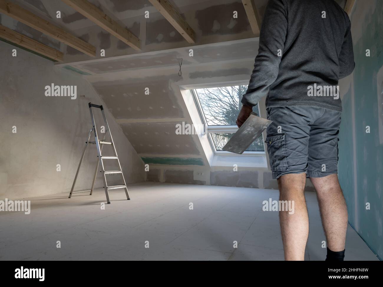 Man plastering drywall in a private house Stock Photo - Alamy