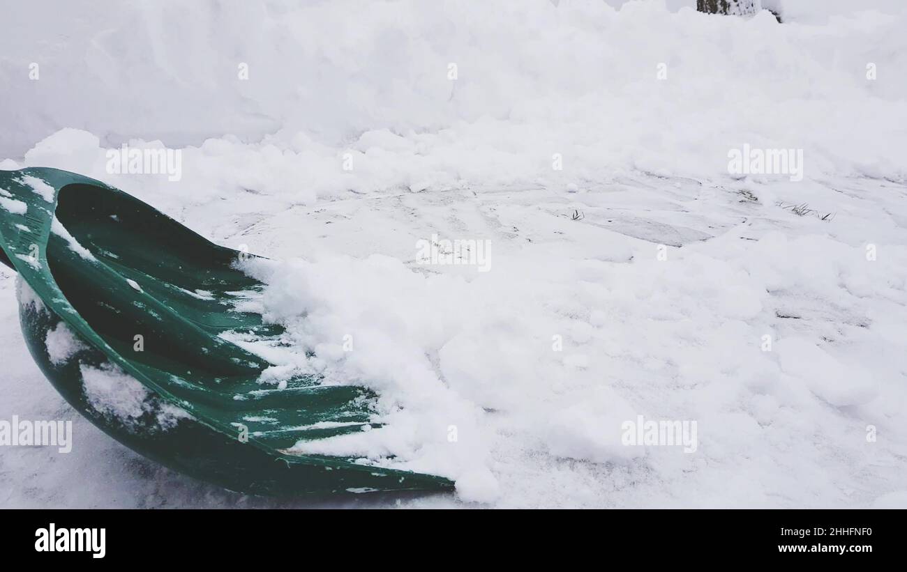 Green snow shovel cleans the sidewalk in winter, side view Stock Photo ...