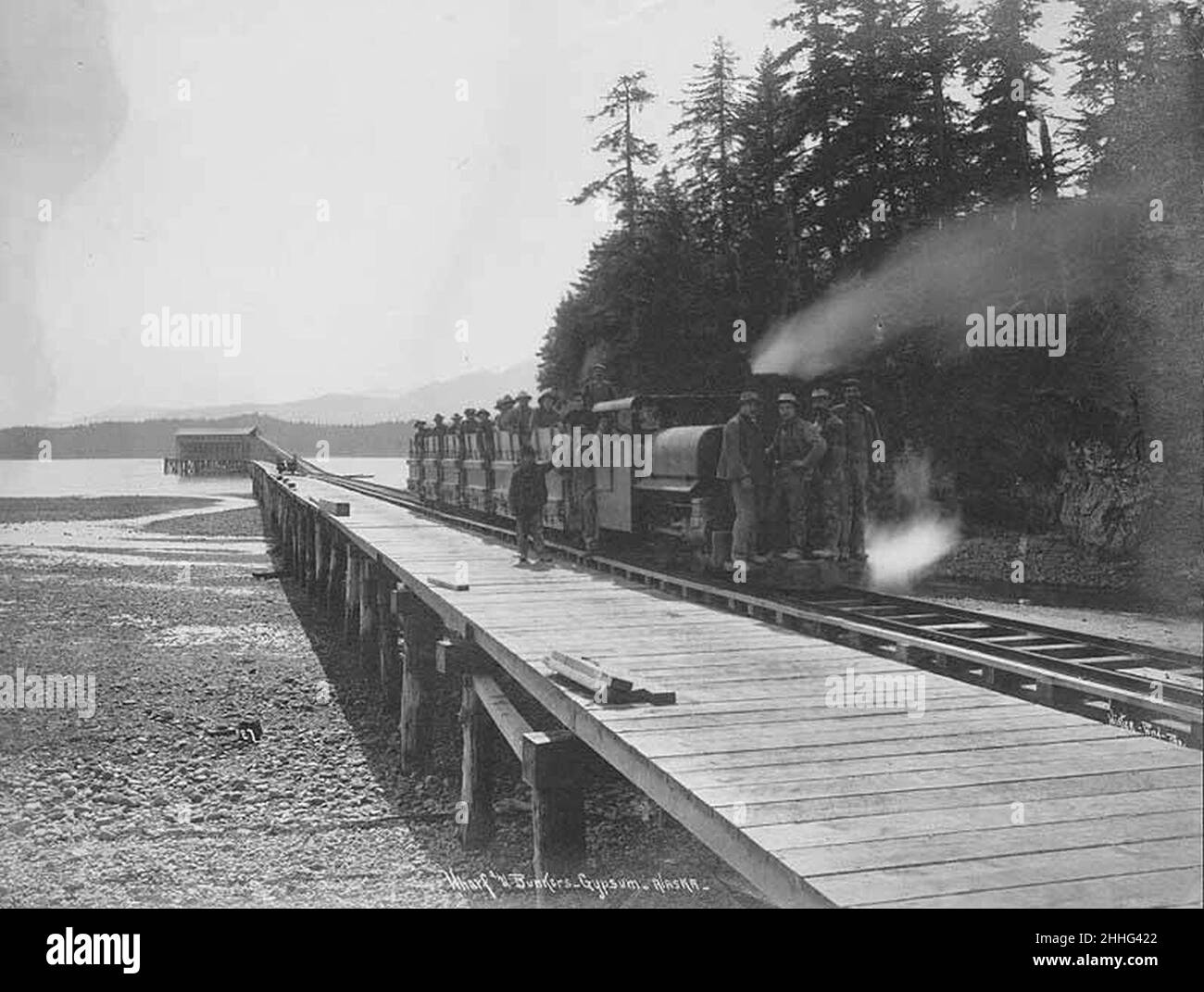 Steam locomotive pulling railroad cars filled with mine personnel on ...