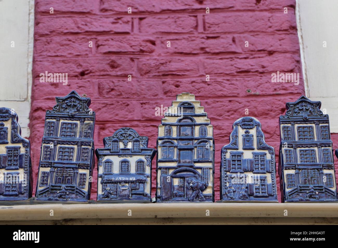 Collection delft blue pottery of dutch houses in front of pink brick ...