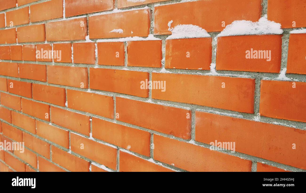 Orange brick wall with snow in snowy day Stock Photo - Alamy