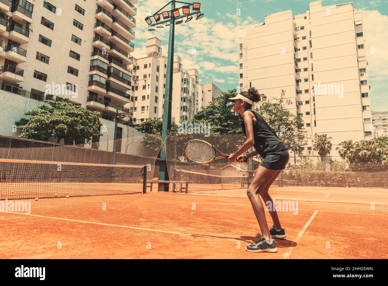 Side view of an African-American tennis player in the practice of ...