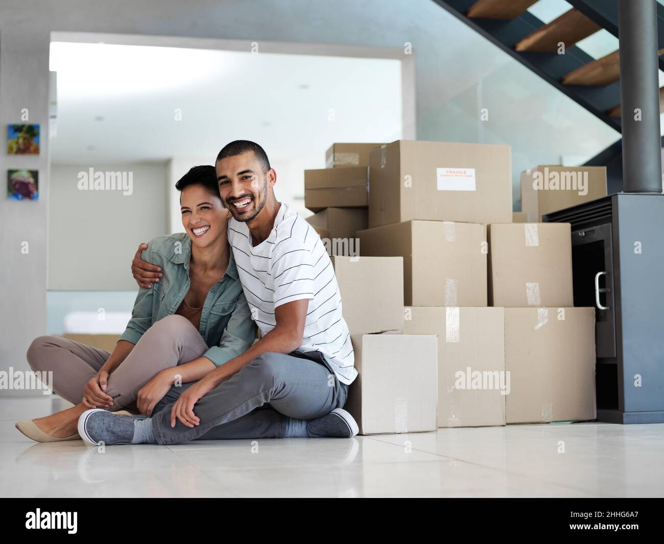 Our own home sweet home. Portrait of a happy young couple sitting on ...