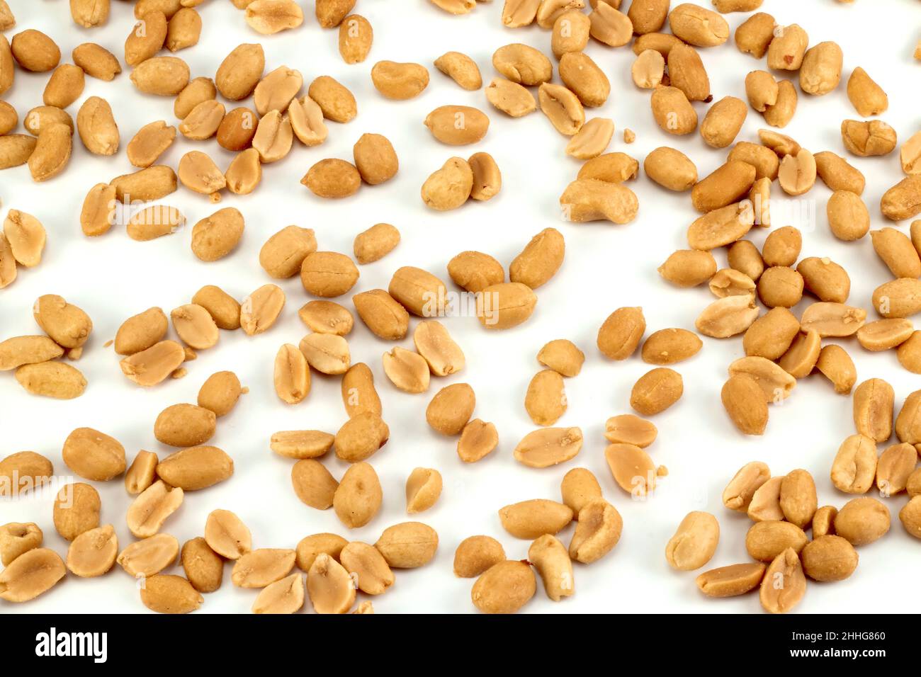 Scattered peeled salted peanuts isolated on white background. Top view ...