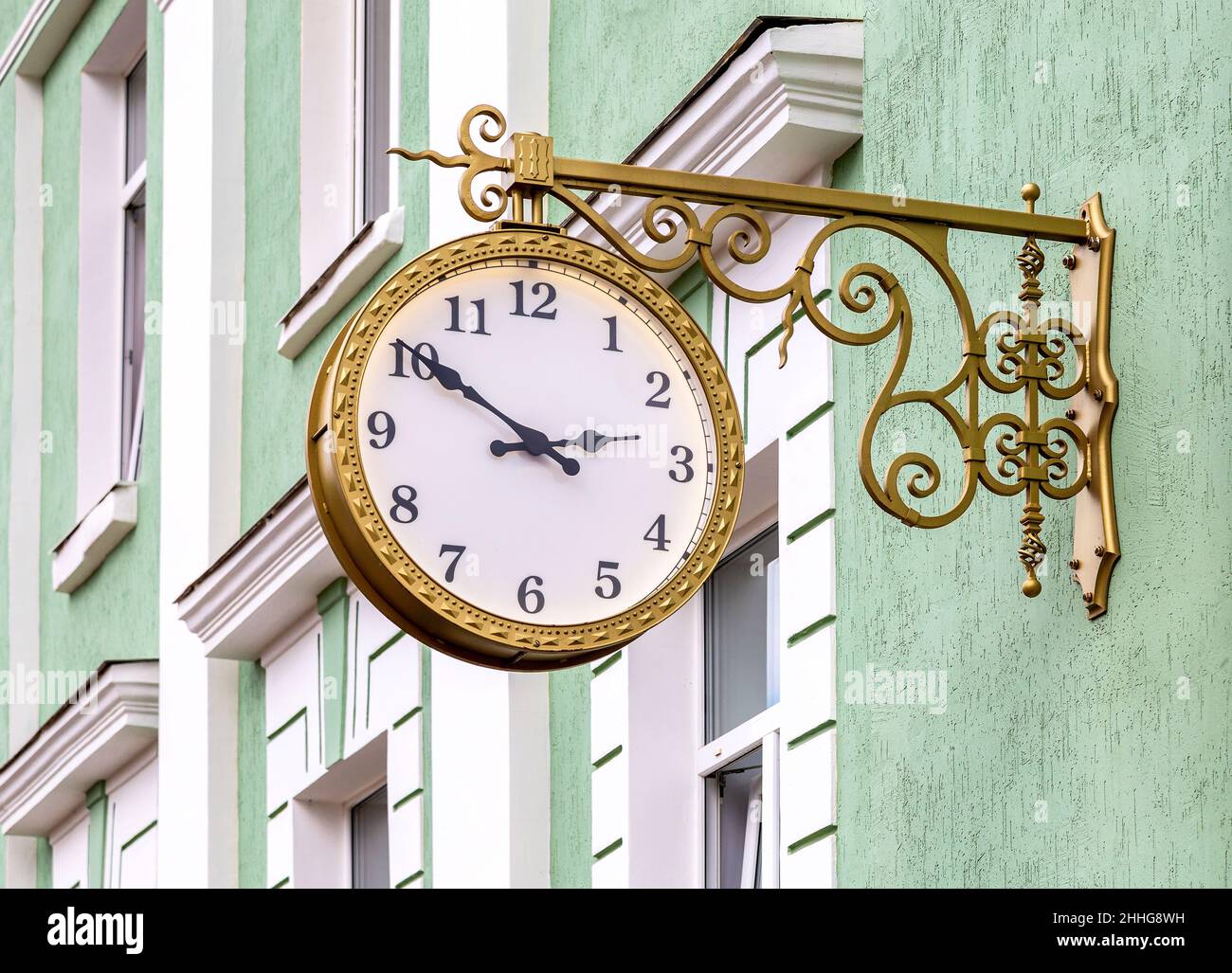 Big street clock hanging on a wall of brick building Stock Photo - Alamy