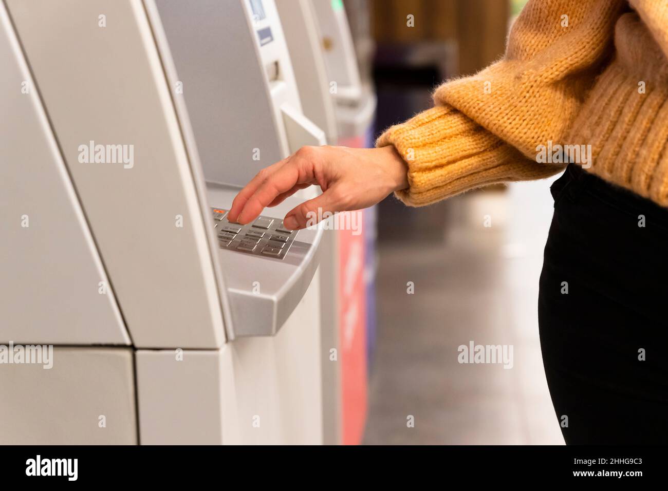 Close up of a womans hand entering secret code on the keypad of an ATM ...