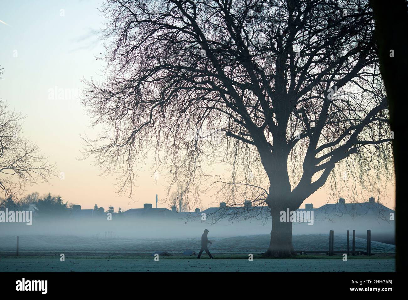 A pedestrian is seen walking through the mist in a park in Ilford, East ...