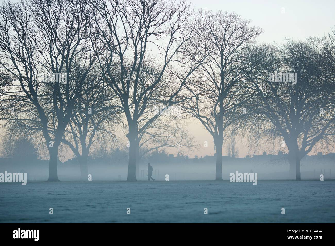 A pedestrian is seen walking through the mist in a park in Ilford, East ...