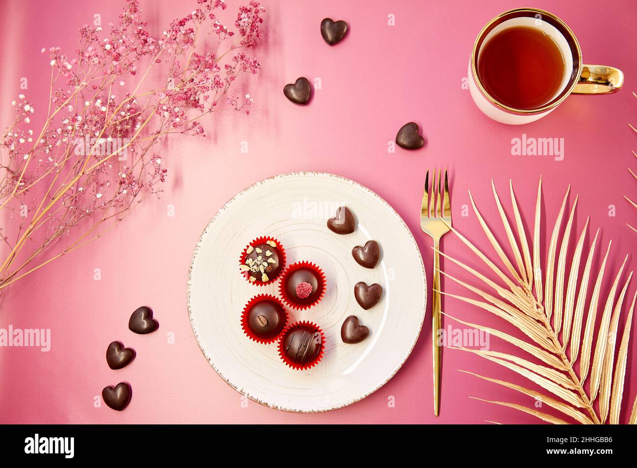 Chocolate hearts and decorated sweets on the white vintage plate with ...