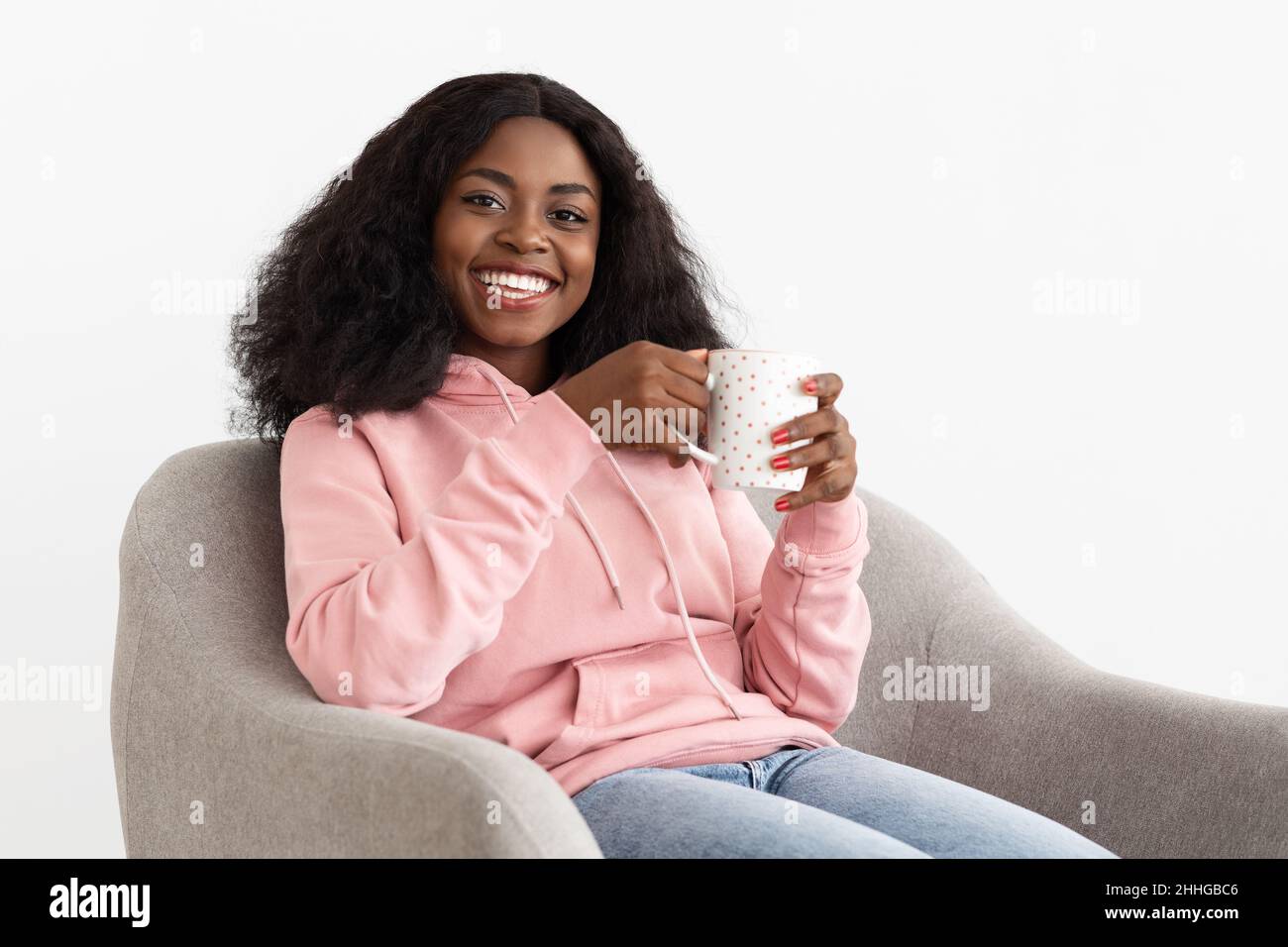 Cheerful pretty african american woman chilling at home, drinking ...
