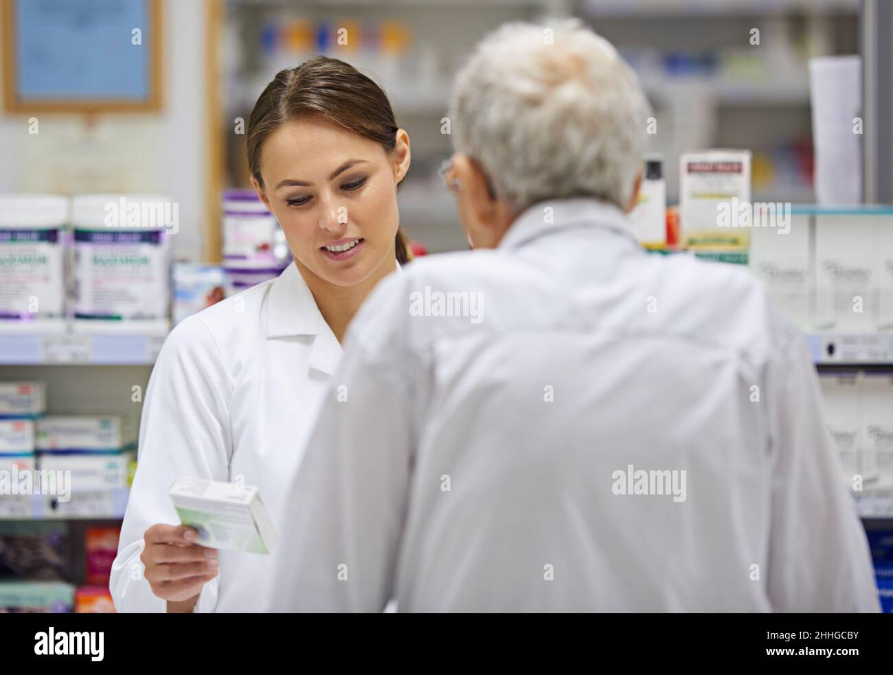 Making medication simple. Shot of a young pharmacist helping an elderly ...