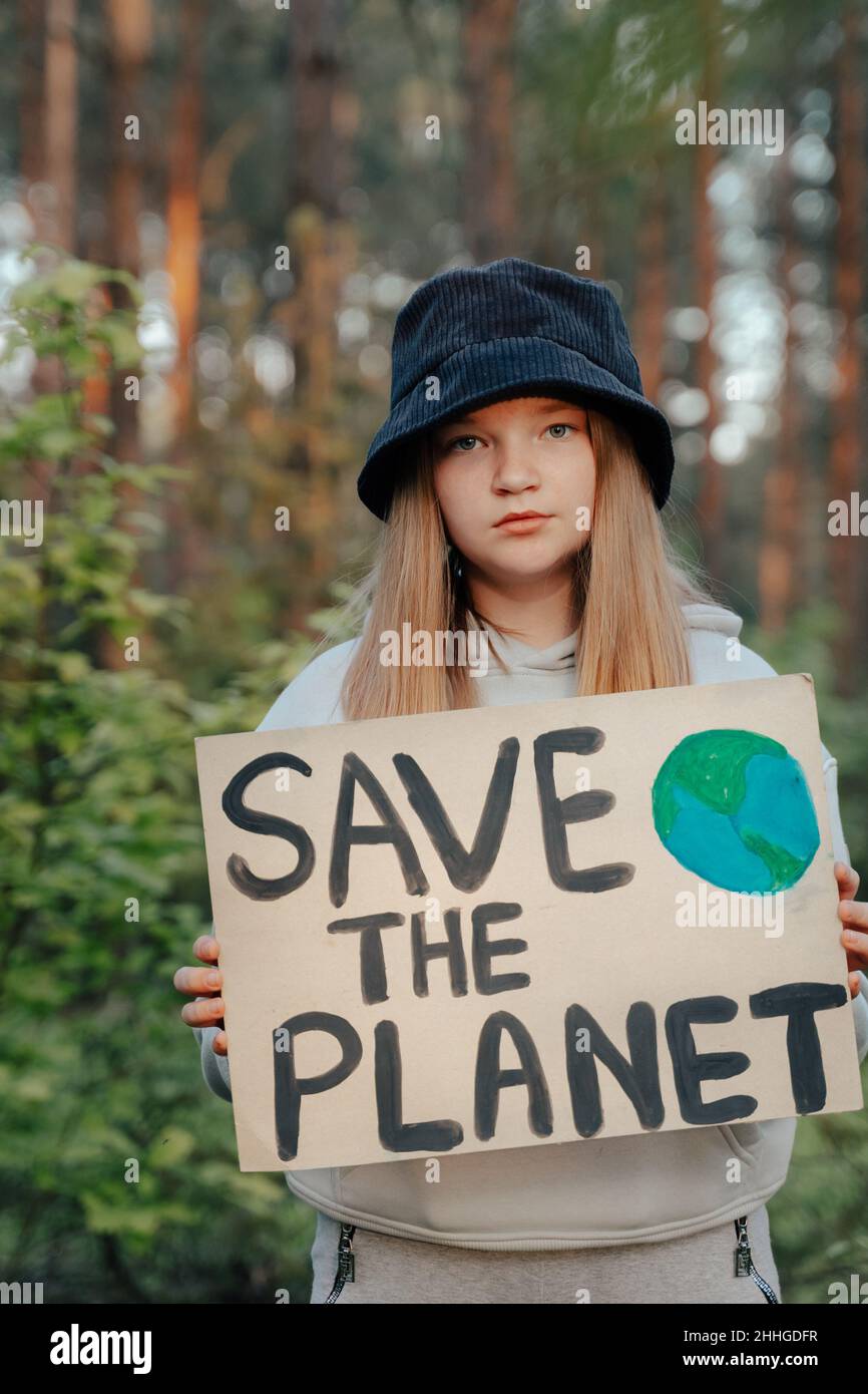 child girl activist with save the planet poster in forest park. preteen ...