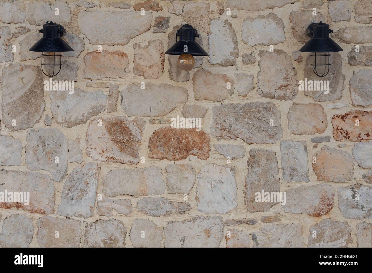 Beautiful street lamps on a stone wall. Background texture of the stone ...