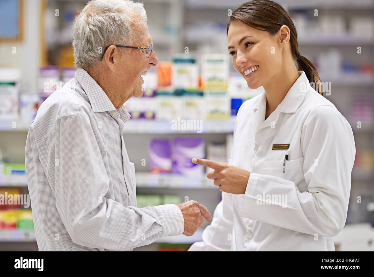 Treating her clients with care. Shot of a young pharmacist helping an ...