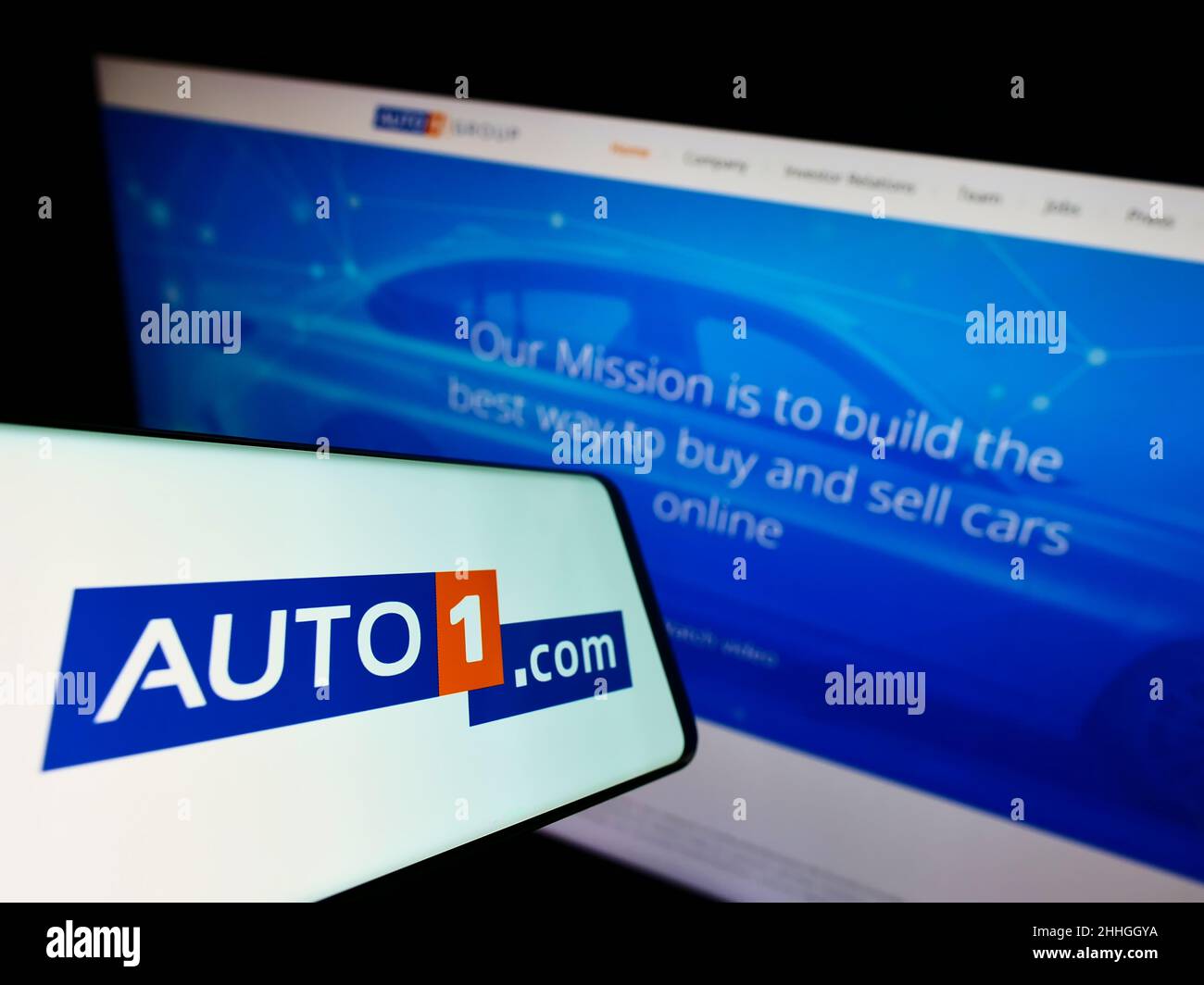 Mobile phone with logo of German car dealing company Auto1 Group SE on screen in front of ...