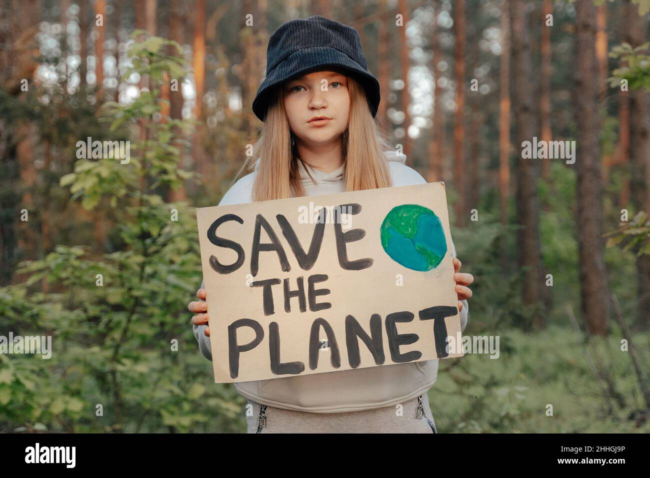 child girl activist with save the planet poster in forest park. preteen ...