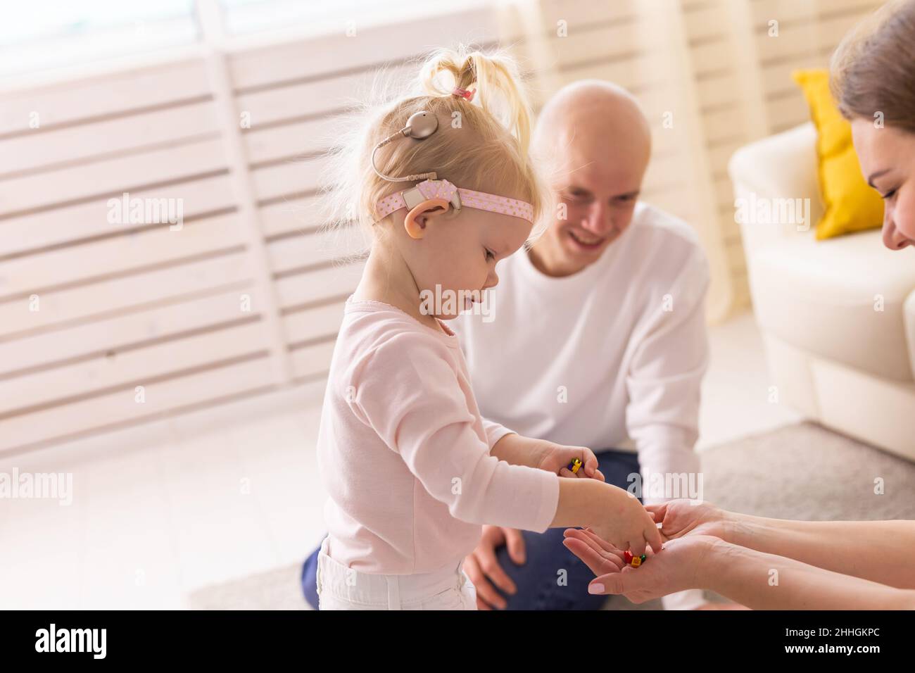 Kid with cochlear implants playing with toys at home. Deafness and ...