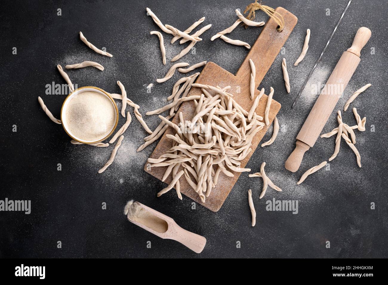 Whole grain wheat apulian pasta Pizzarieddi or maccaruni on a cutting ...