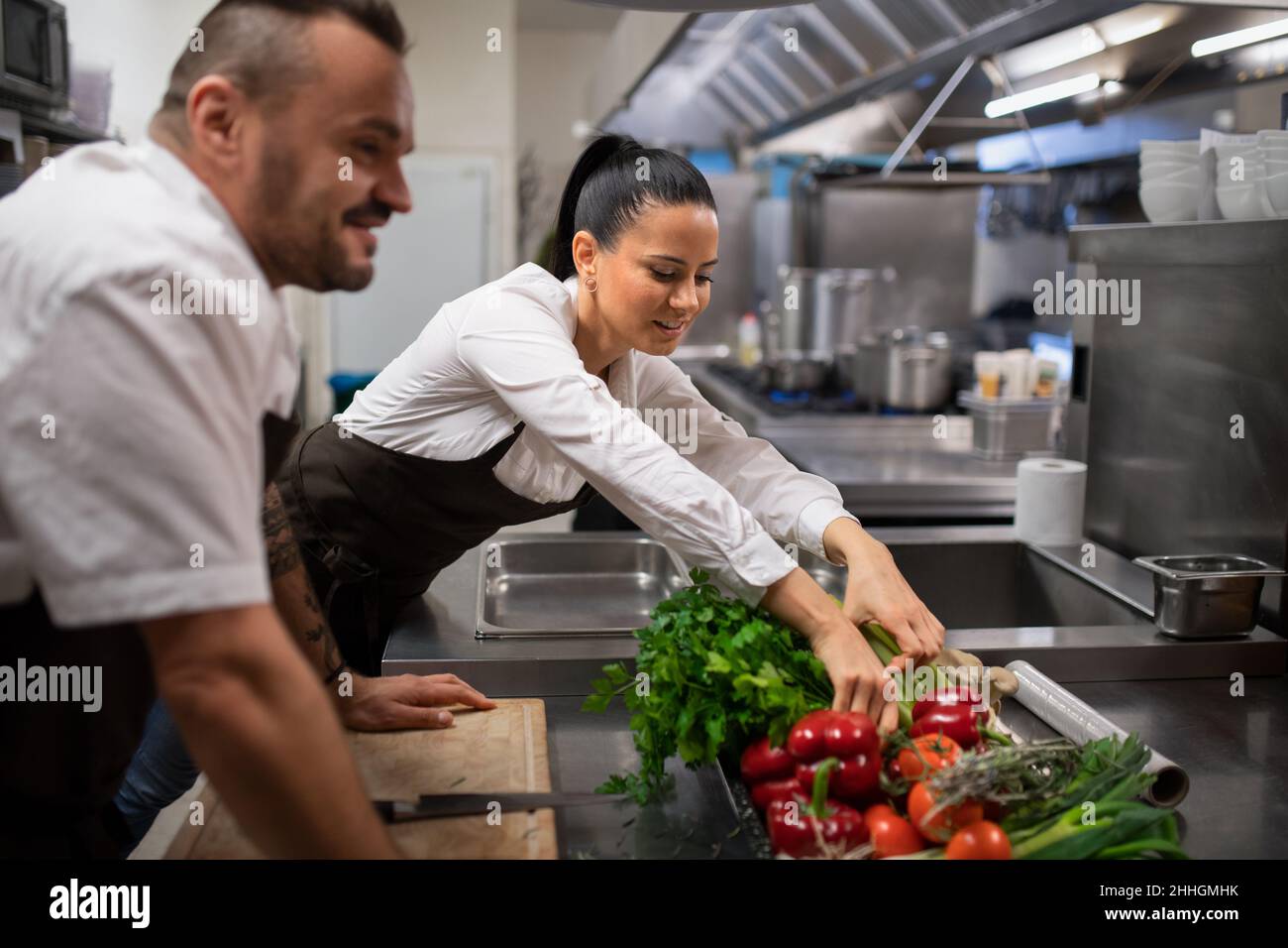 Chefs preparing vegetables for cutting in commercial kitchen Stock ...