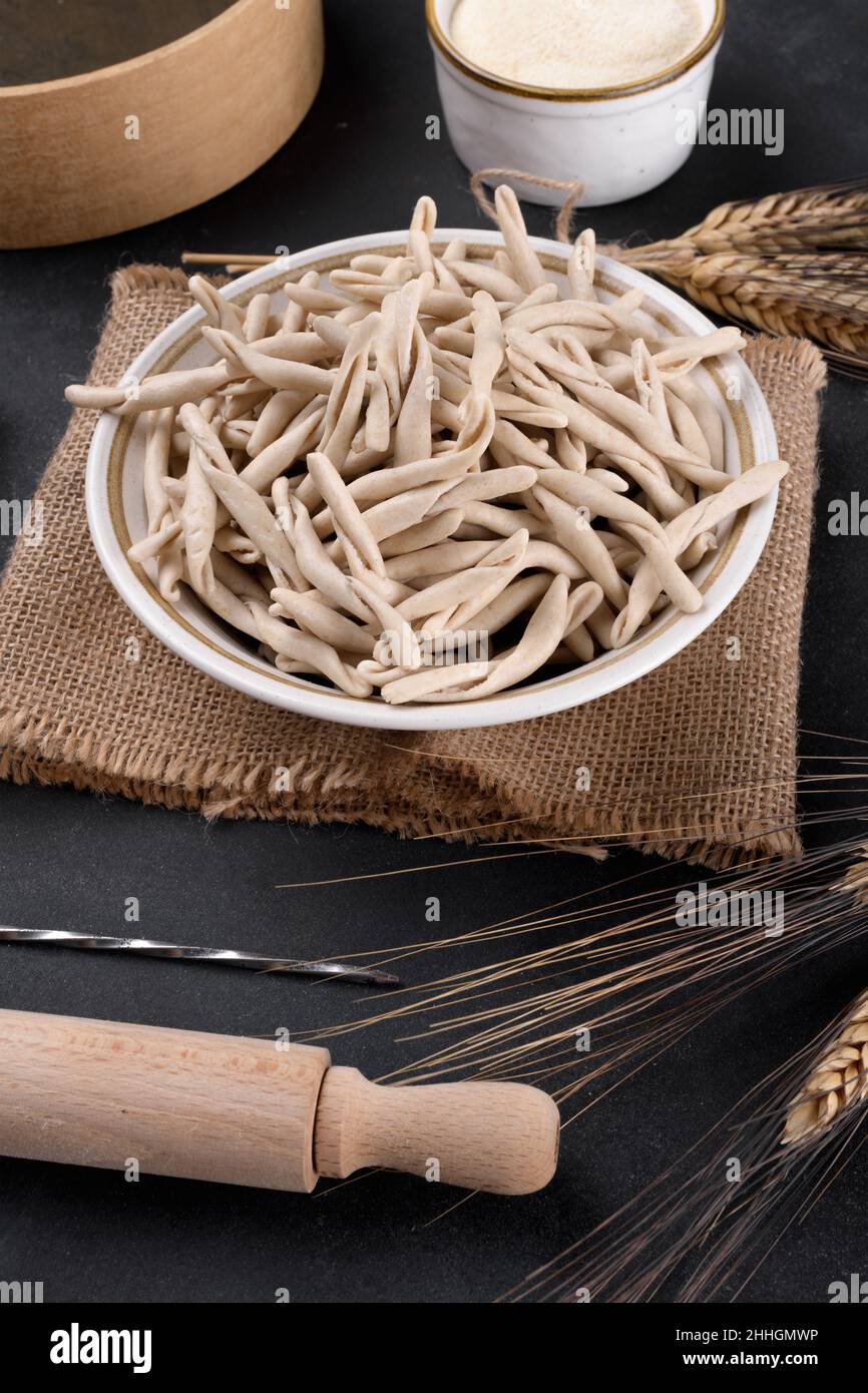 Whole grain wheat raw apulian pasta Pizzarieddi or maccaruni in a bowl ...