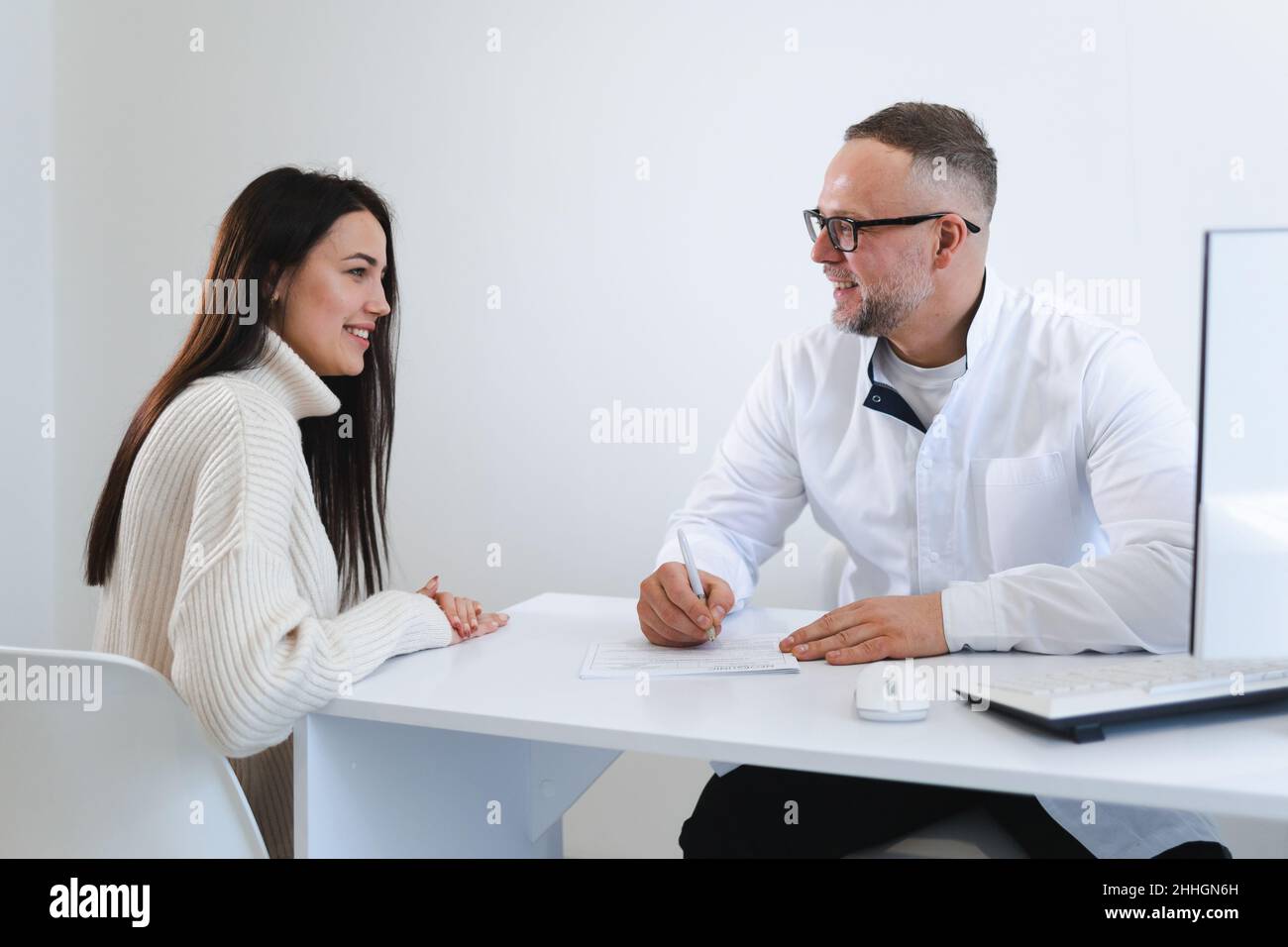 Happy female physician writing hi-res stock photography and images - Alamy