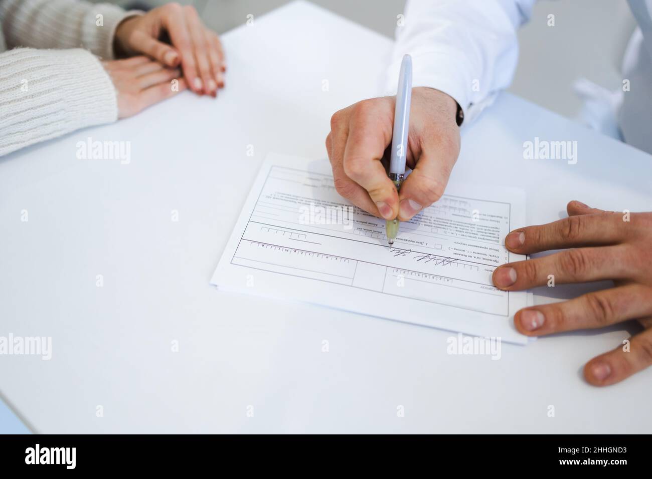 Close up view of male doctor's hands writes a prescription for the ...