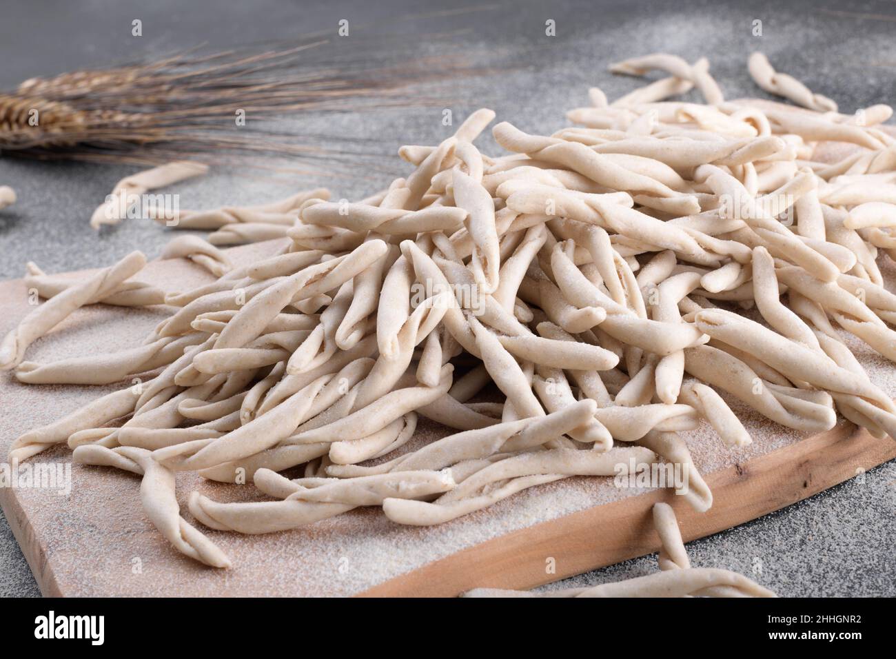 Whole grain wheat apulian pasta Pizzarieddi or maccaruni on a cutting ...