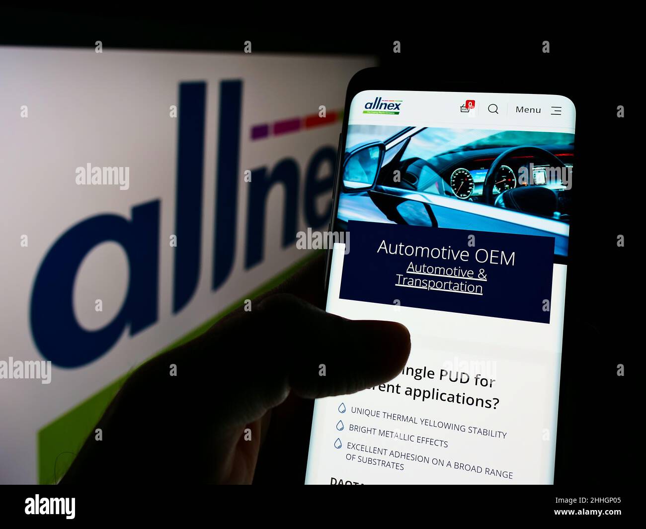 Person holding cellphone with webpage of German chemicals company ...