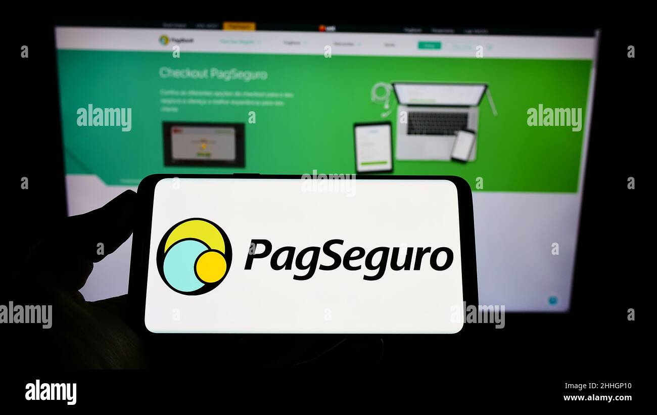 Person holding mobile phone with logo of Brazilian fintech company ...