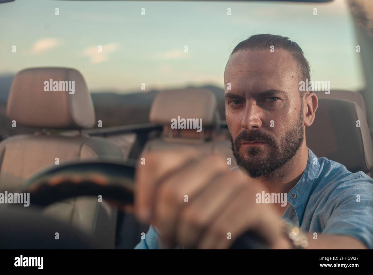 Portrait of man driving convertible car in landscape Stock Photo - Alamy