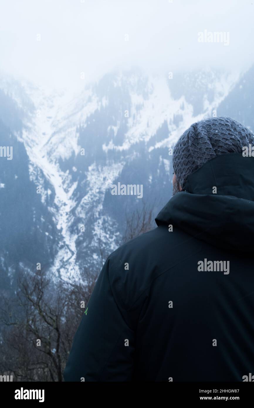 Turkey, Rear view of man facing mountain covered with snow and fog ...