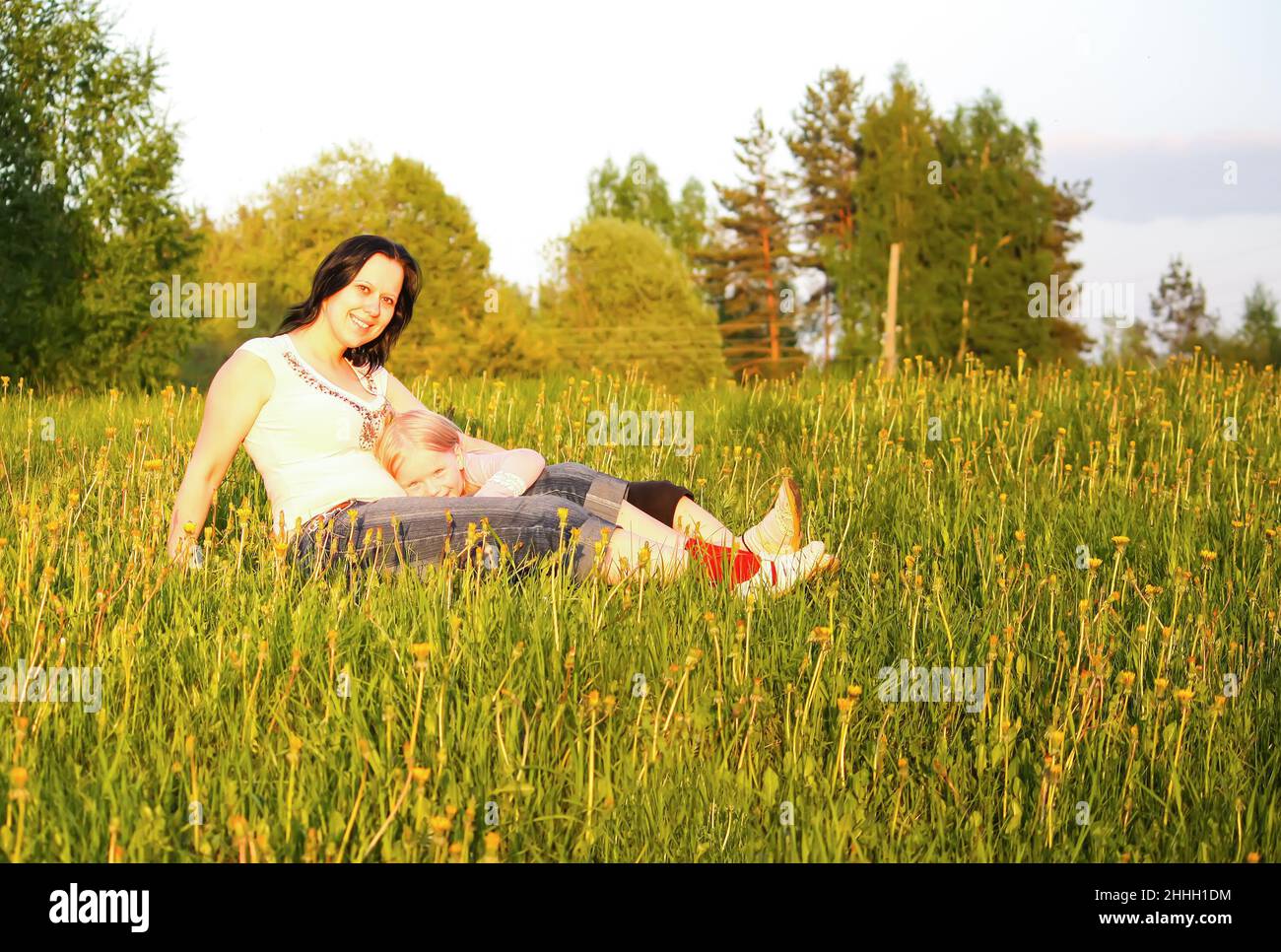 Mother and daughter on green meadow in sunlight Stock Photo - Alamy