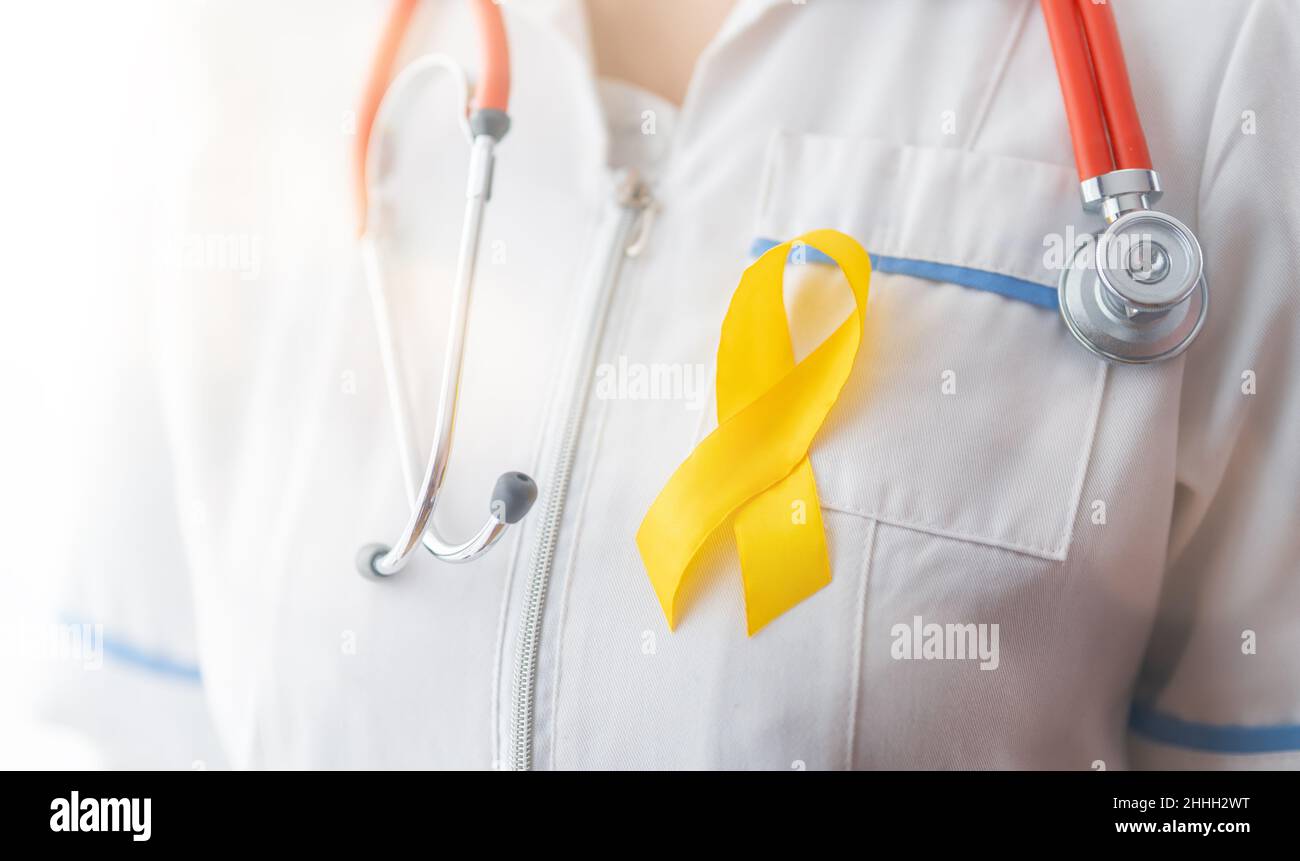 World Childhood cancer Day. Doctor with golden ribbon Stock Photo - Alamy