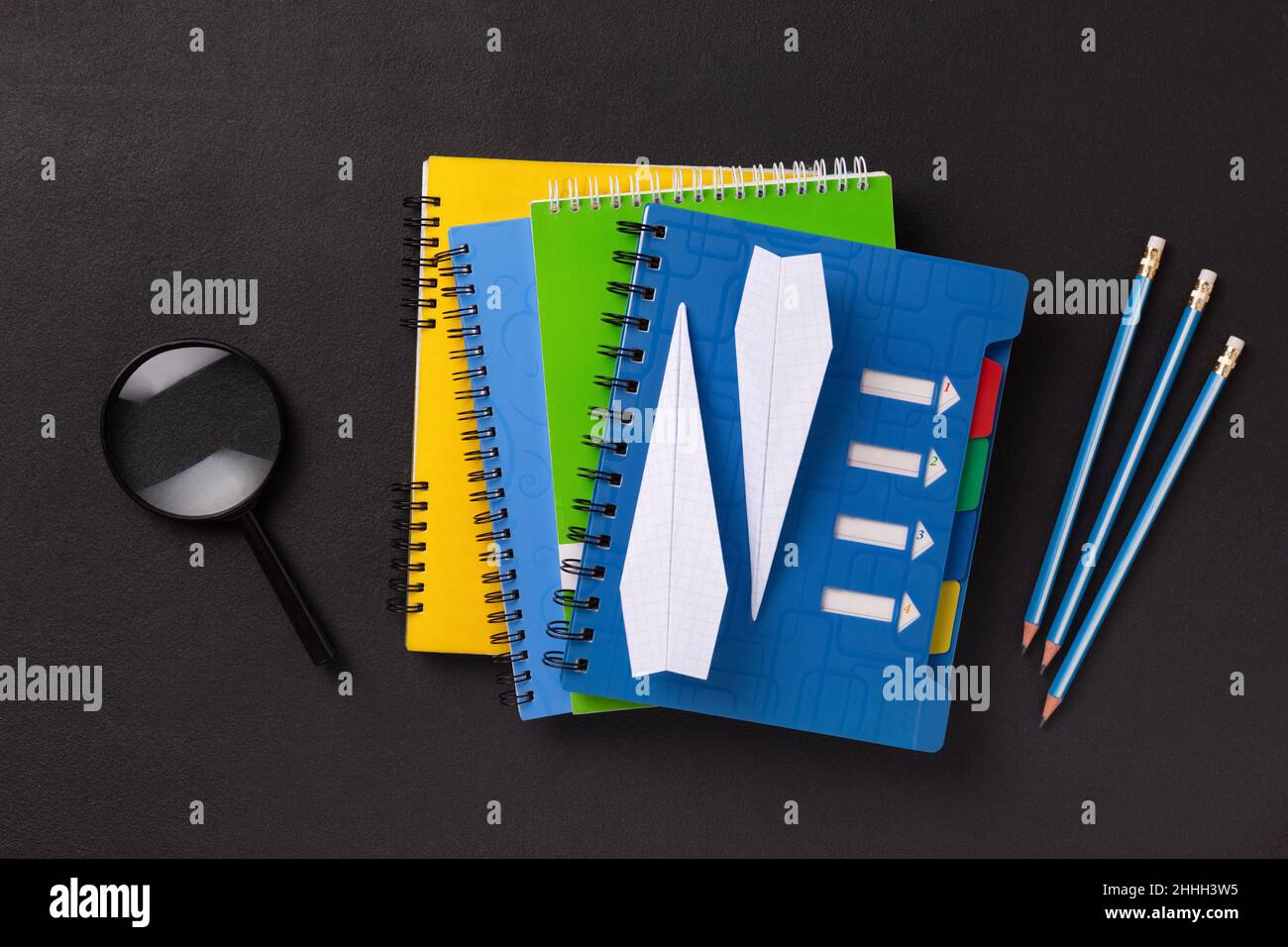 A stack of colorful notebooks of a student or school pupil on a black ...