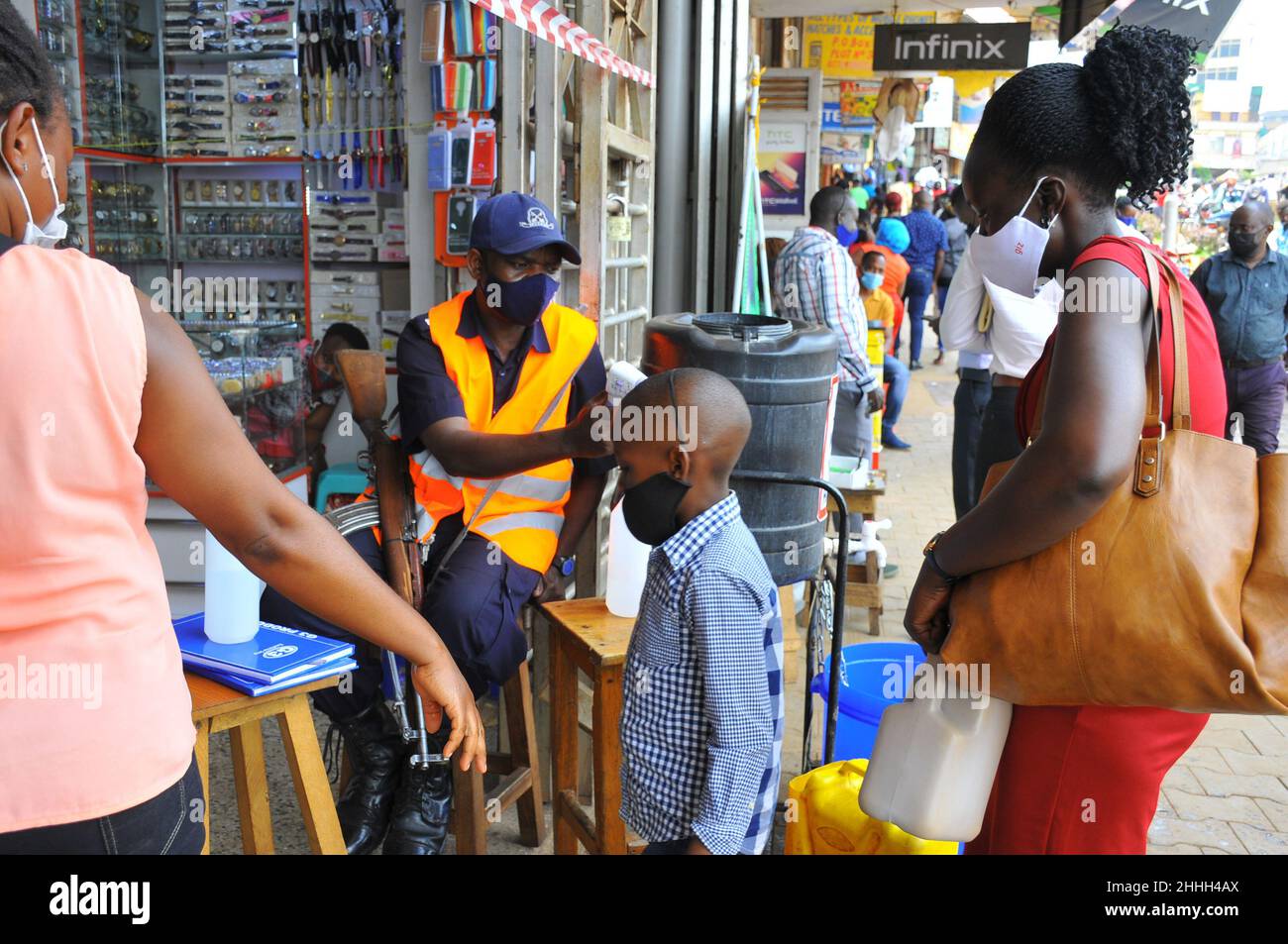 A security guard checking the temperature of a child due to the Covid ...