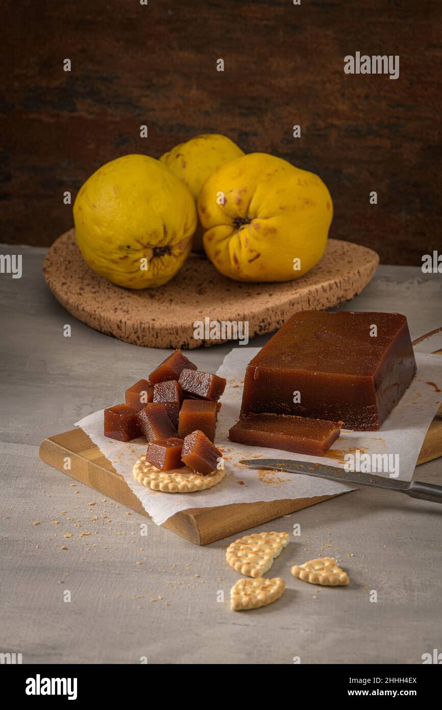 Marmalade in crackers on a kitchen counter with quinces on a cork tray ...