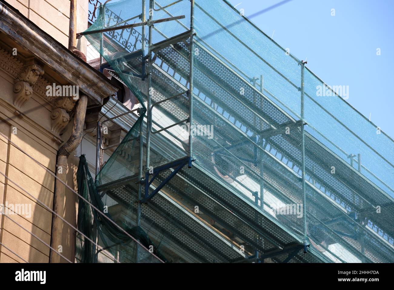 Building facade under renovation works with construction scaffolding ...