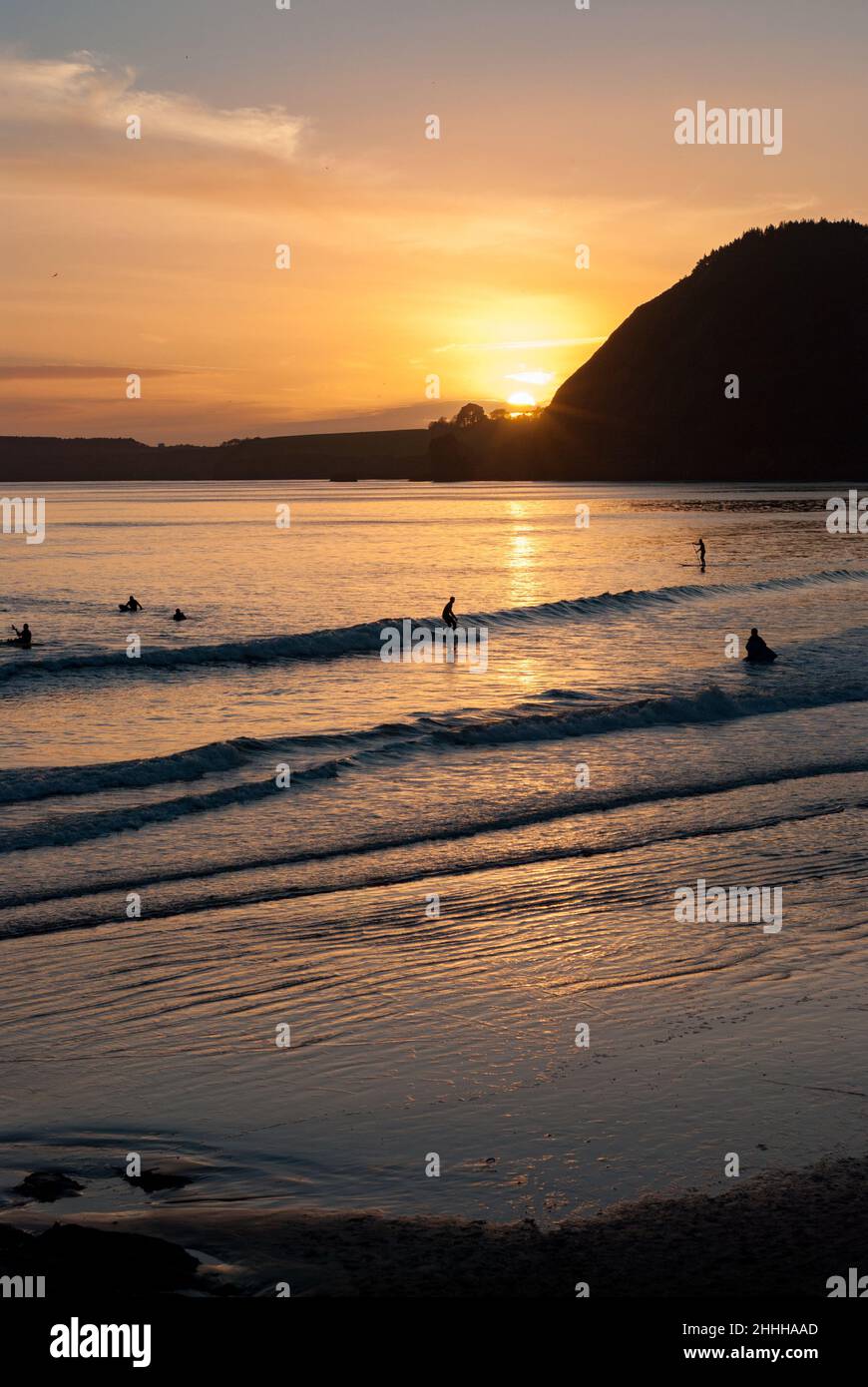 UK, England, Devonshire. Surfing at Sidmouth in East Devon at sunset ...