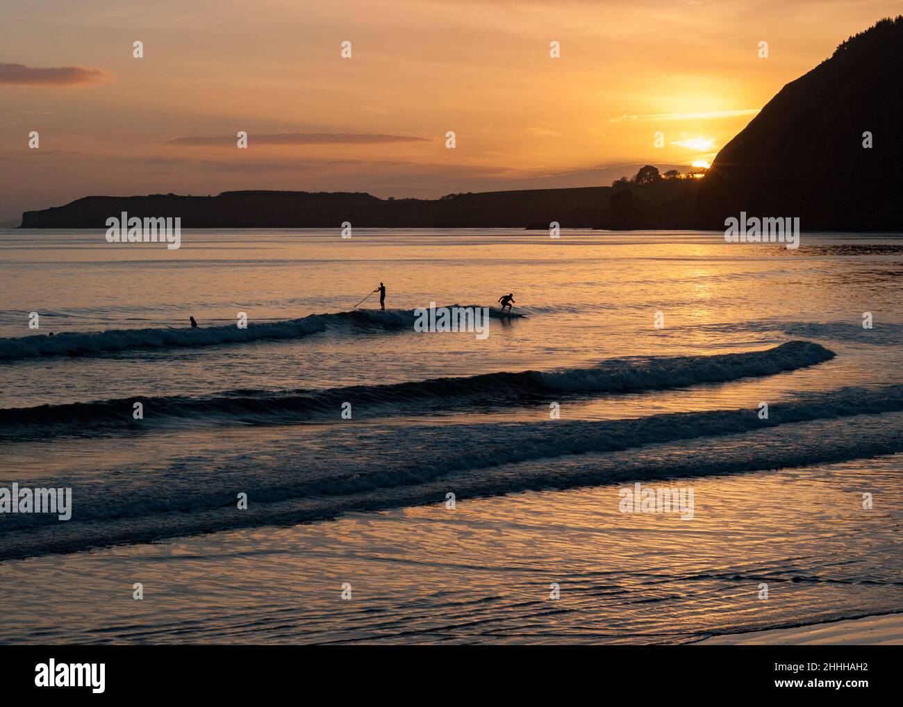 UK, England, Devonshire. Surfing at Sidmouth in East Devon at sunset ...