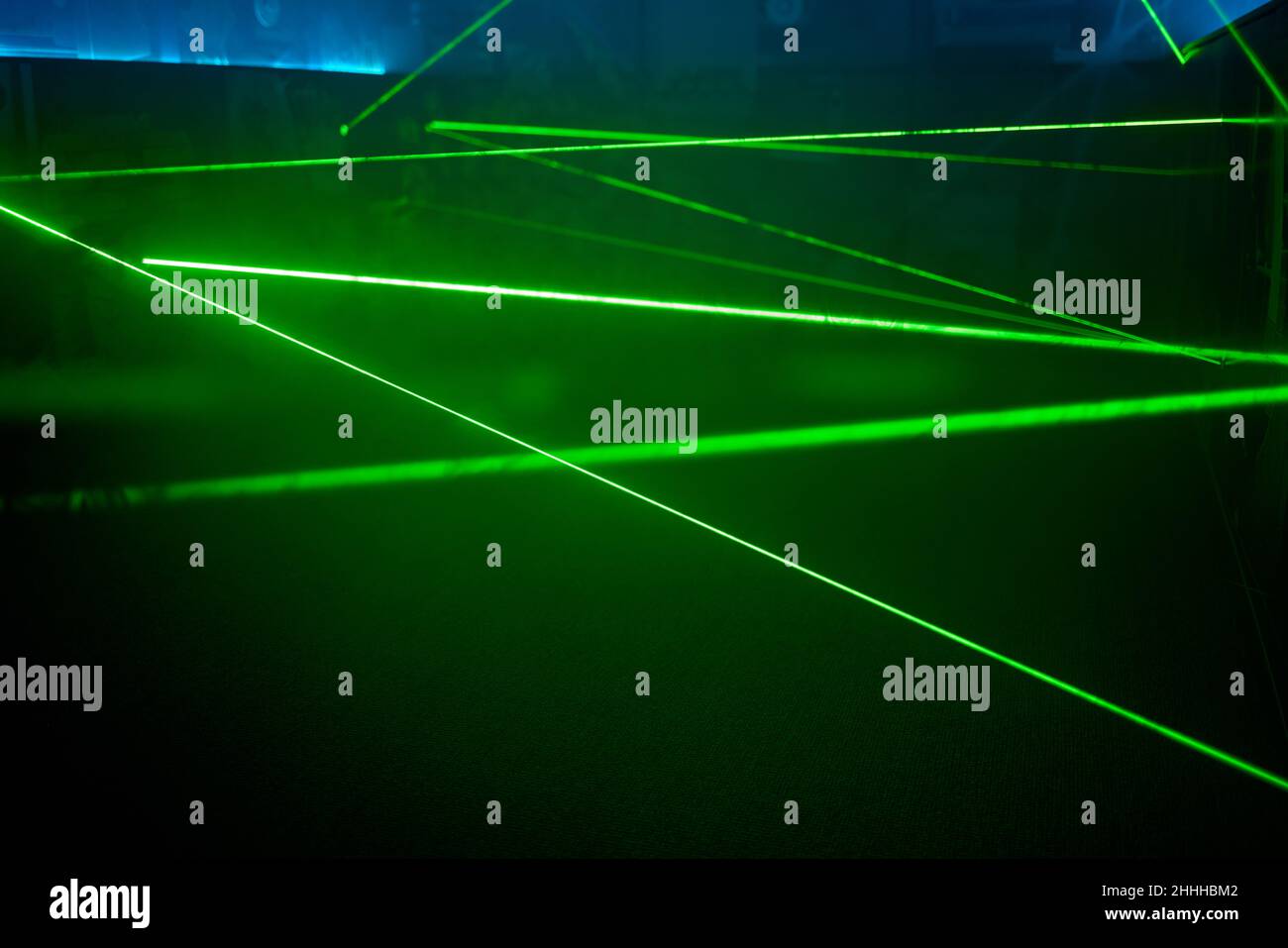 Bright green neon laser lights illuminate the darkness creating lines ...
