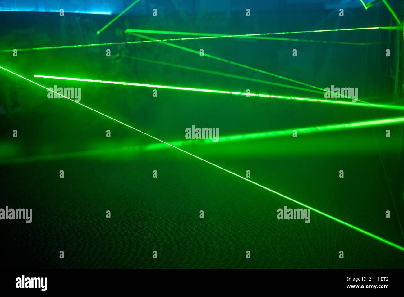 Bright green neon laser lights illuminate the darkness creating lines ...
