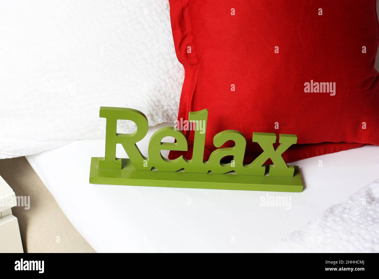 Sign with the word "Relax" green color on a red and white background ...