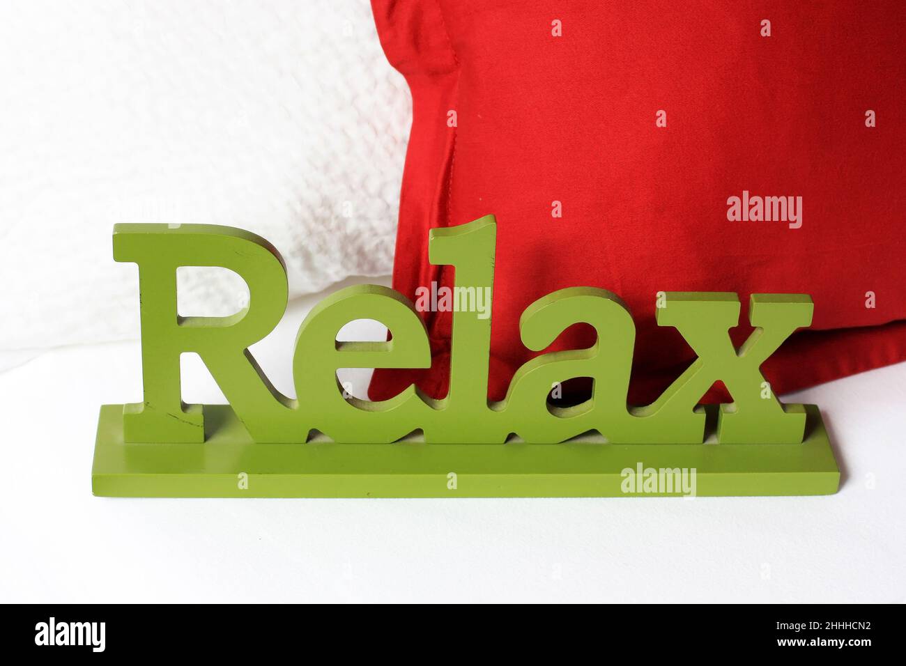Sign with the word "Relax" green color on a red and white background ...