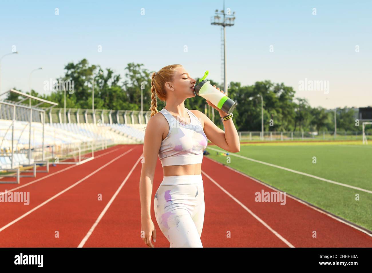 Young woman drinking protein shake at sport stadium Stock Photo - Alamy